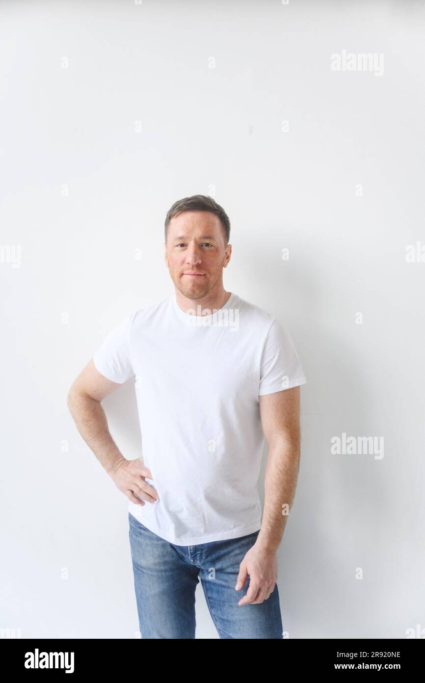 Man with hand on hip against white background Stock Photo - Alamy