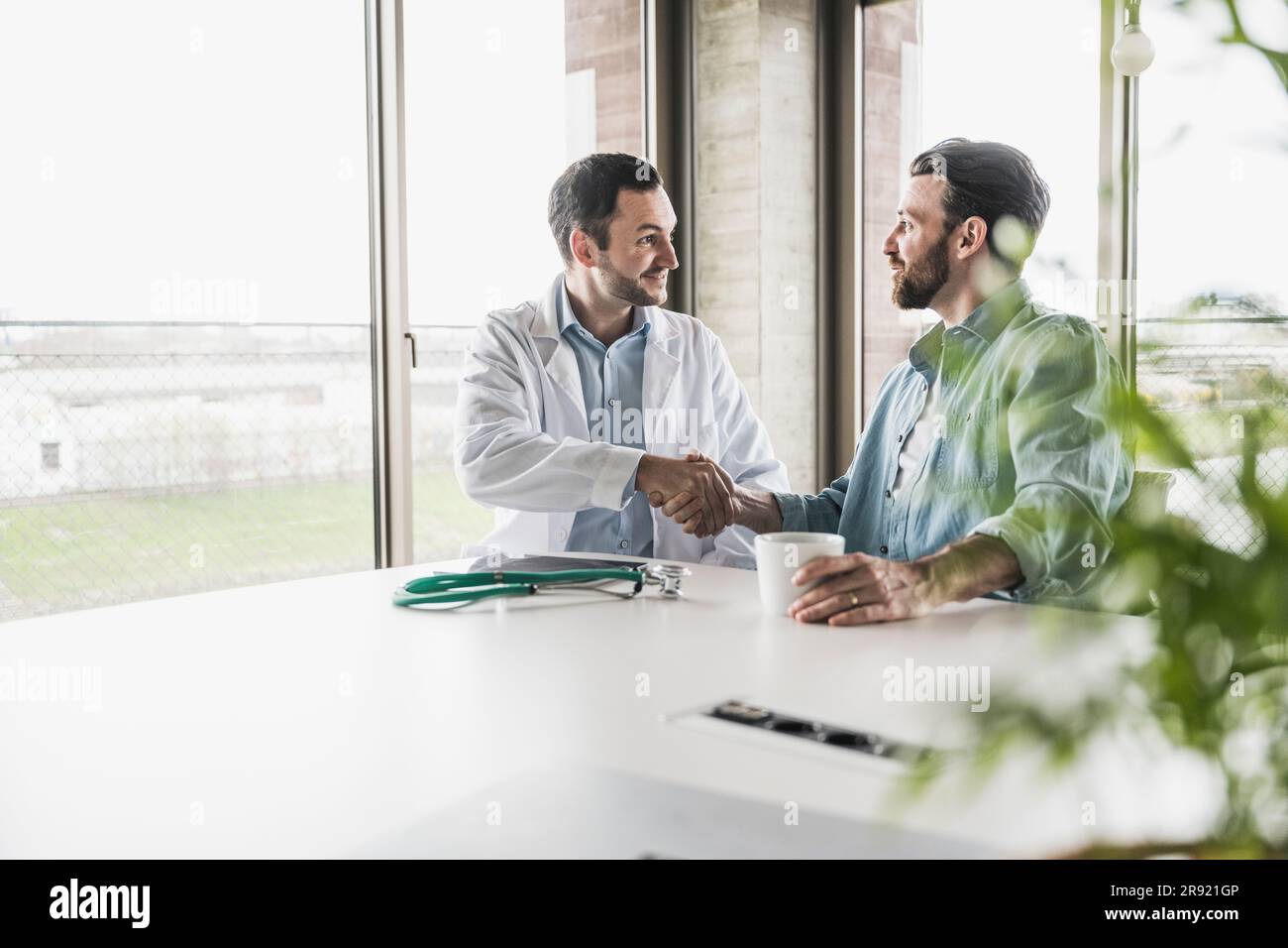 Doctor shaking hand with patient at clinic Stock Photo - Alamy