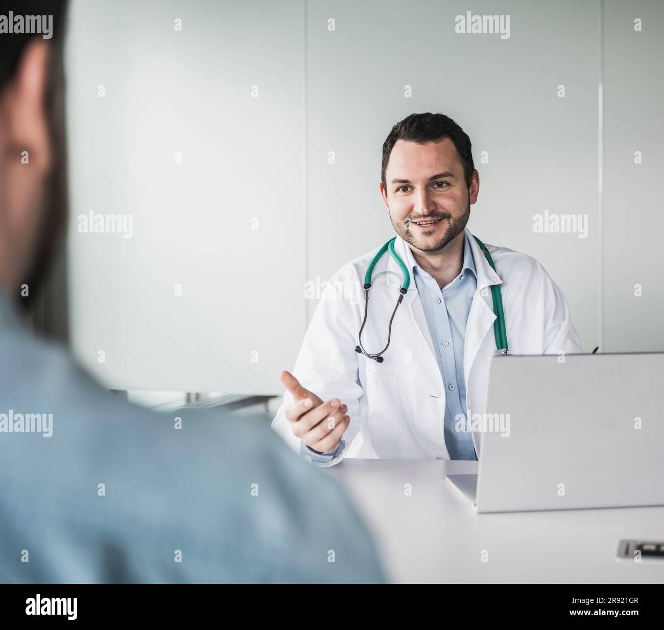 Smiling doctor explaining patient at clinic Stock Photo - Alamy