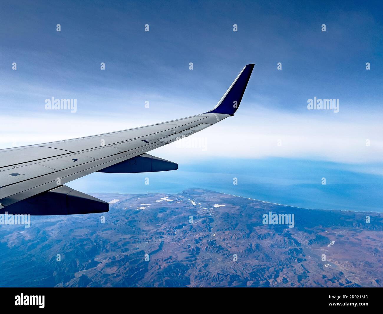 Wing of an airplane flying over the Sea of Cortez and the Pacific Ocean ...