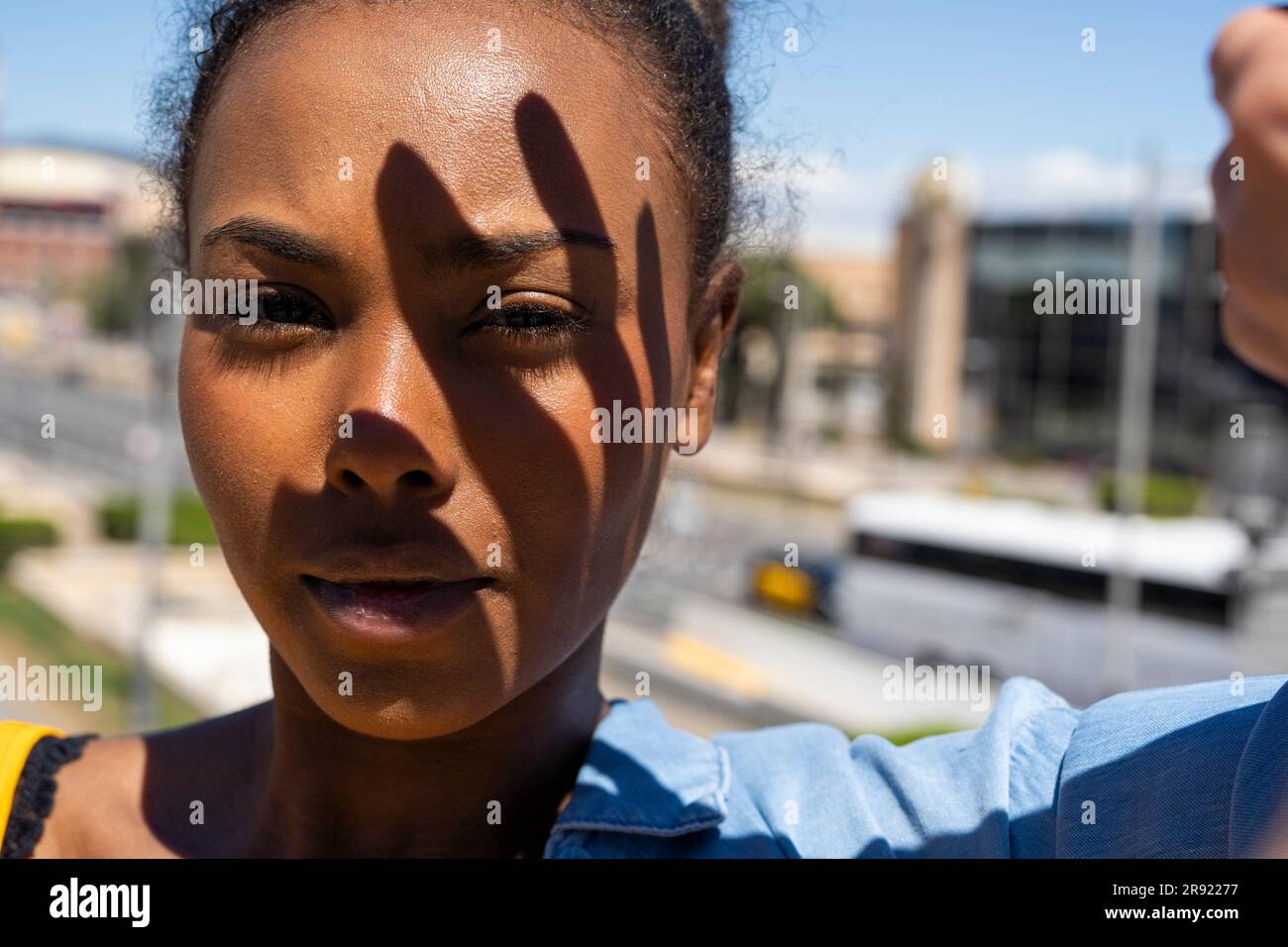 Woman shielding face form sunlight Stock Photo - Alamy