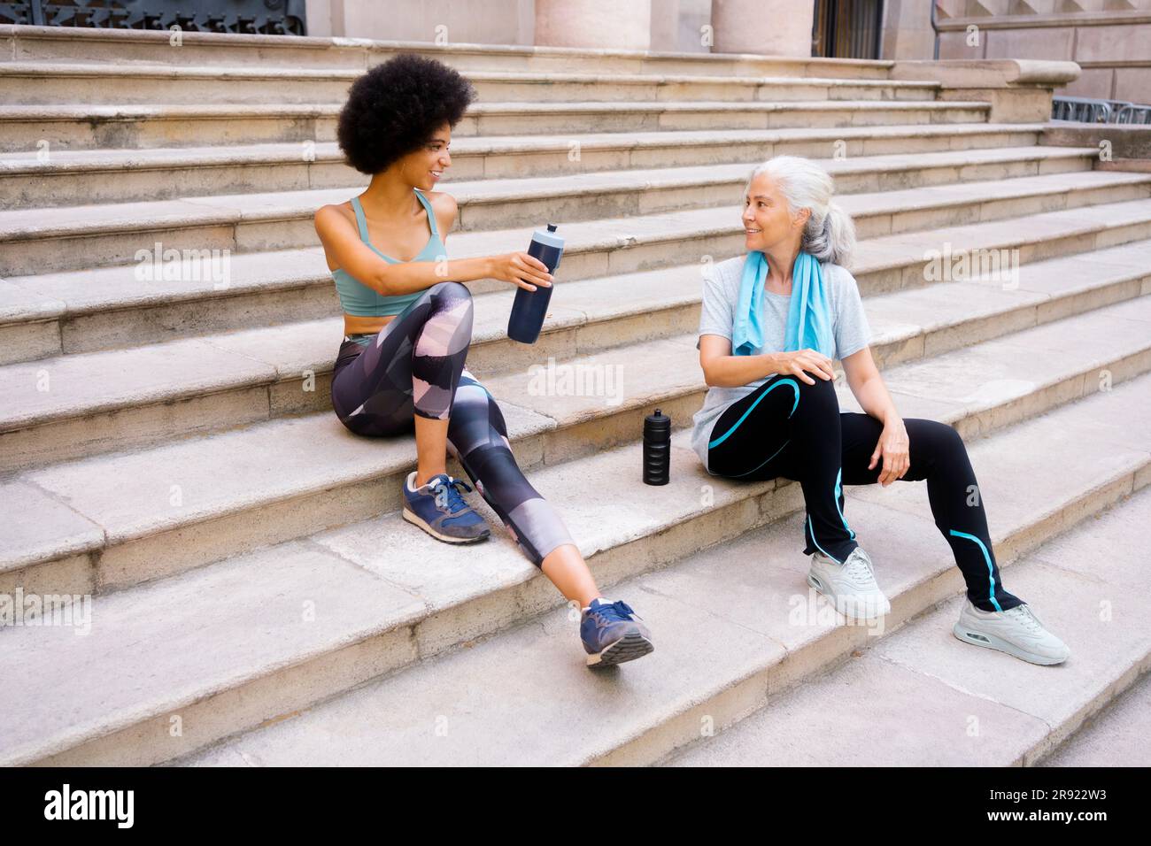Mother and daughter sitting on steps after exercising Stock Photo - Alamy