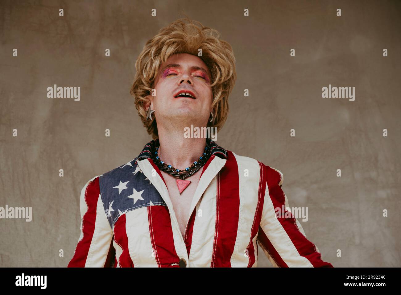 Drag queen with eyes closed in front of wall Stock Photo - Alamy