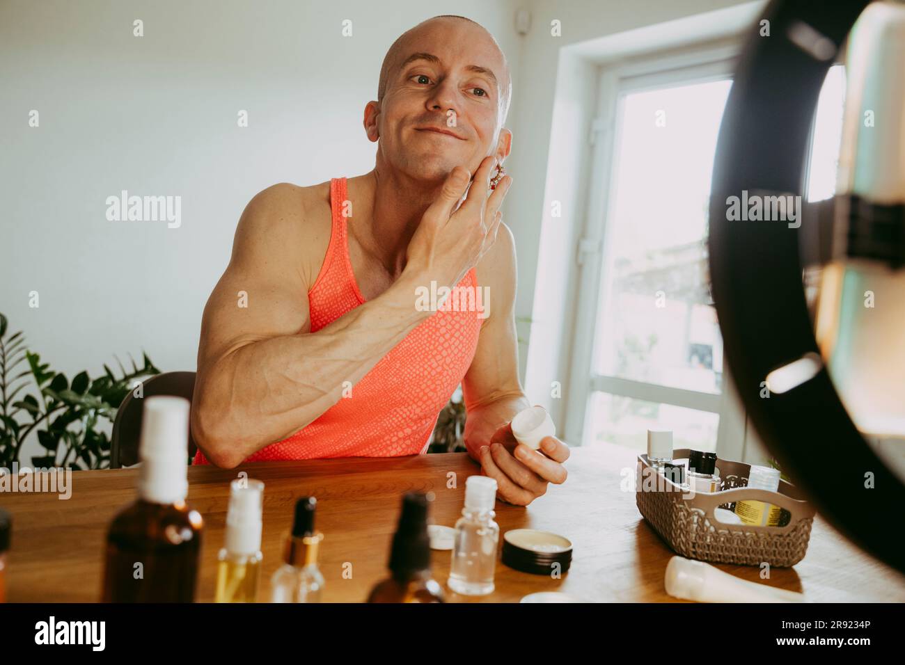 Smiling man applying cream and making vlog at home Stock Photo - Alamy