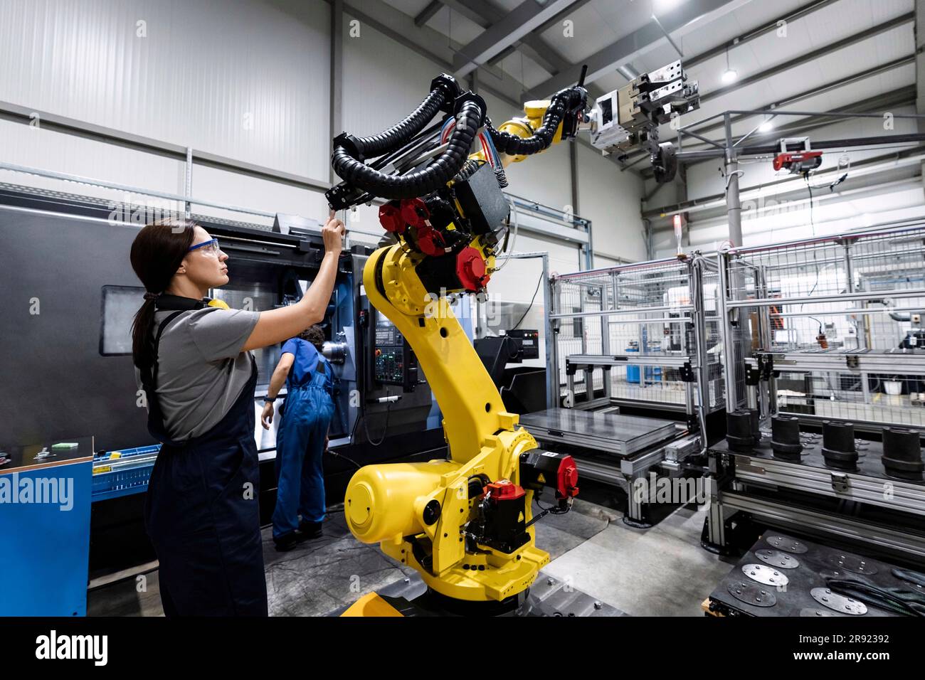Maintenance engineer working in factory using robotic arm Stock Photo - Alamy