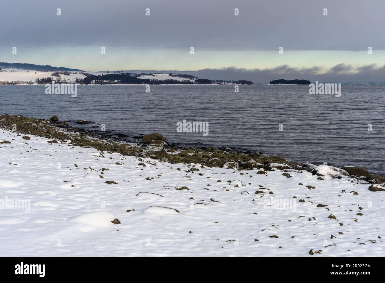 A scenic winter view of the shoreline of Lake Mjosa, with Helgoya ...