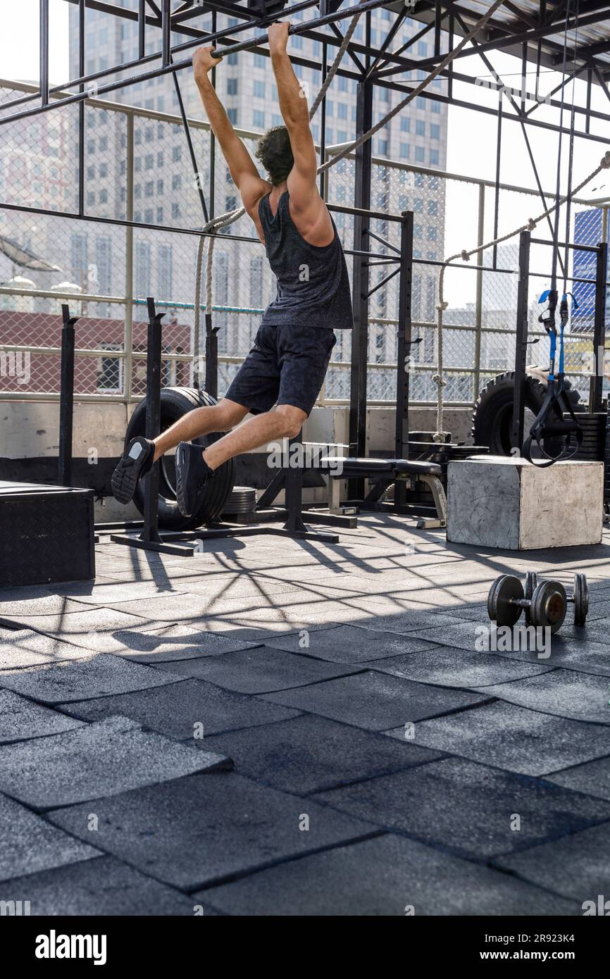 Man doing Calisthenics at rooftop gym Stock Photo - Alamy