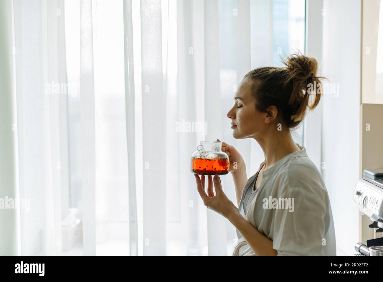 Woman with eyes closed smelling freshly brewed tea Stock Photo - Alamy