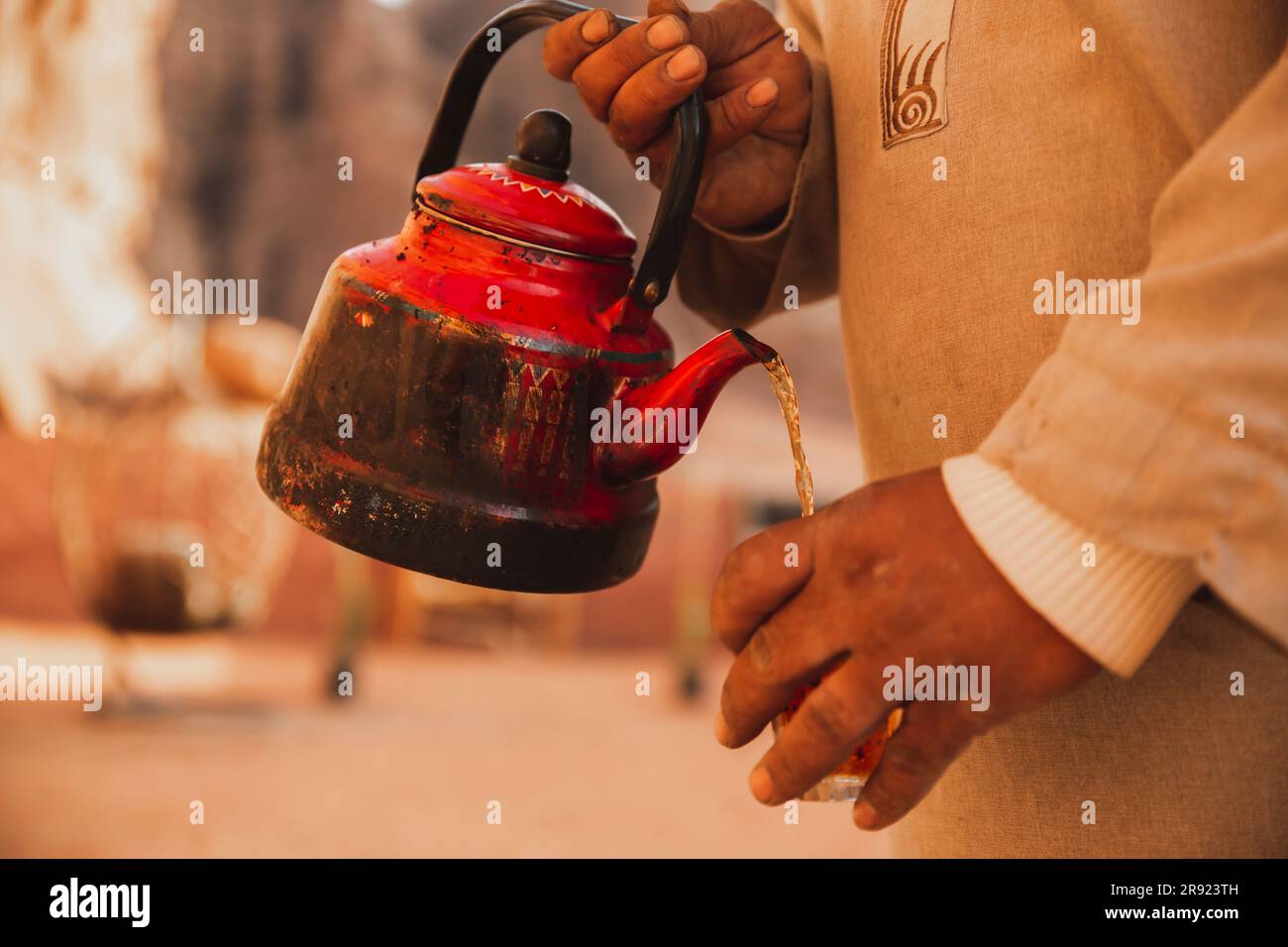 Man with teapot pouring tea in cup Stock Photo - Alamy