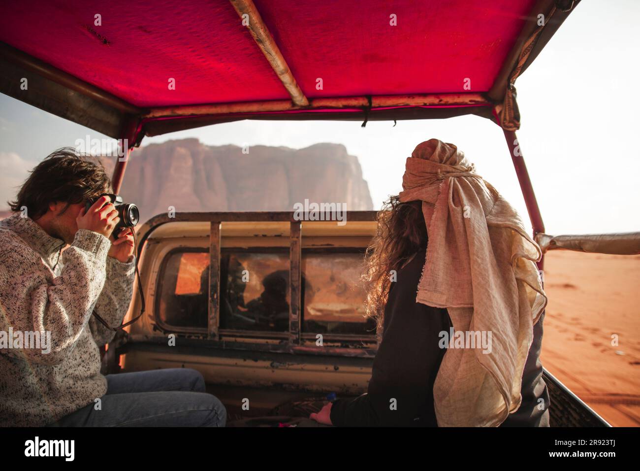 Man photographing woman through camera in car on a desert trip Stock ...