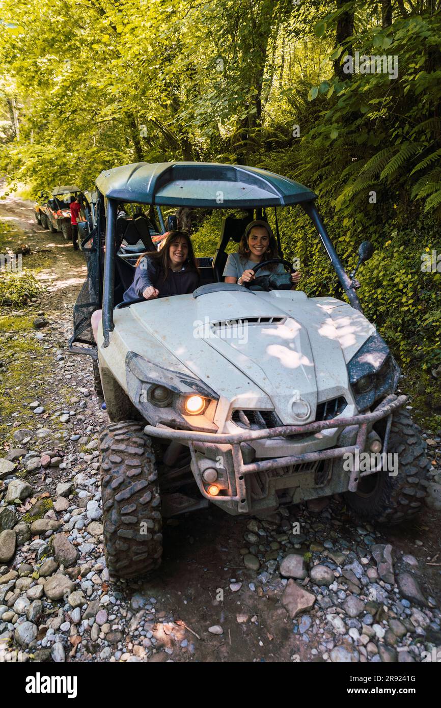 Friends driving buggy and spending vacation at forest Stock Photo - Alamy