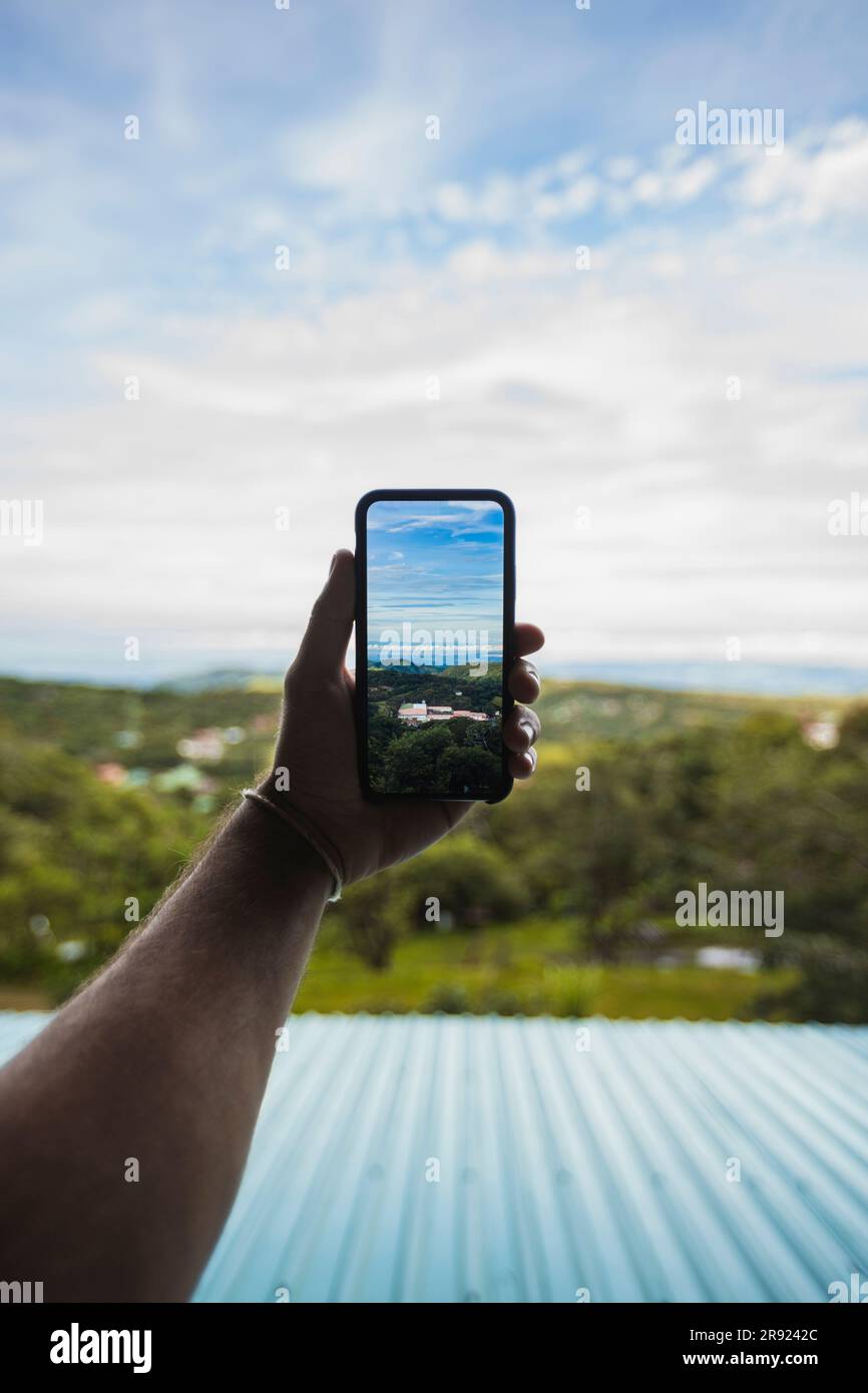 Hand of man clicking photograph of nature through smart phone Stock ...