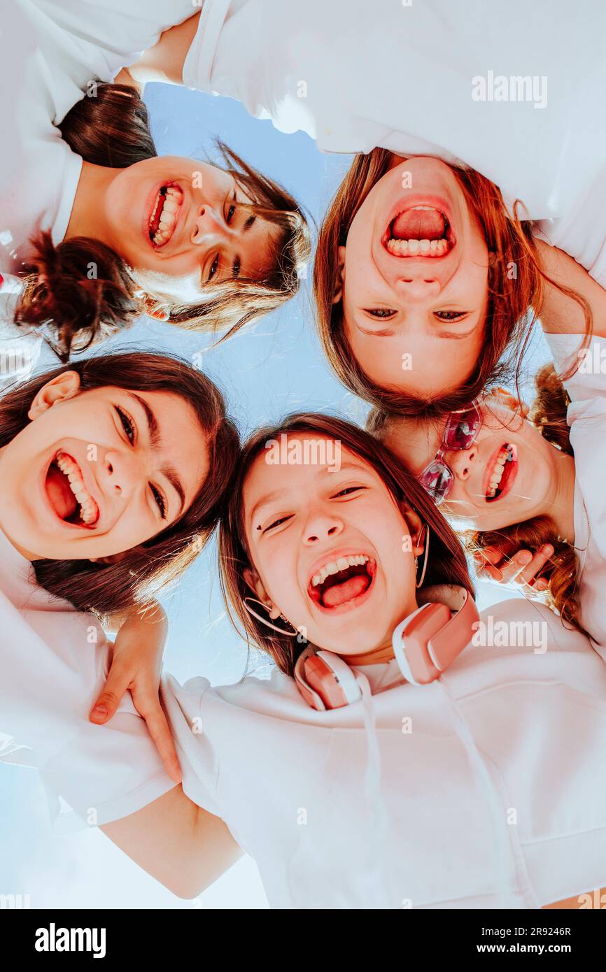 Happy teenage friends screaming and huddling with arms around Stock ...