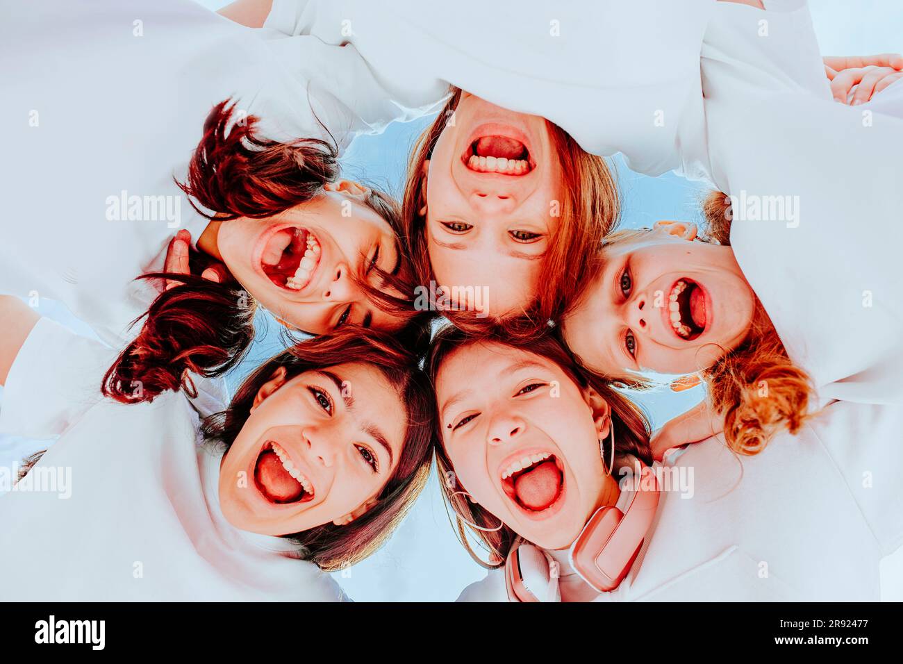 Happy teenage friends screaming and huddling together Stock Photo - Alamy