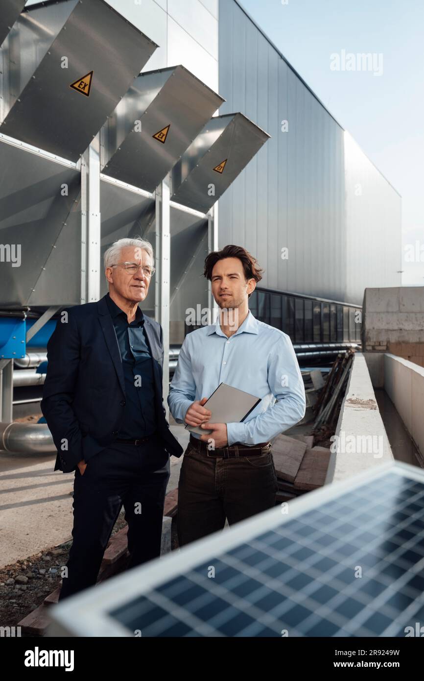 Businessmen standing together in front of industrial building Stock ...