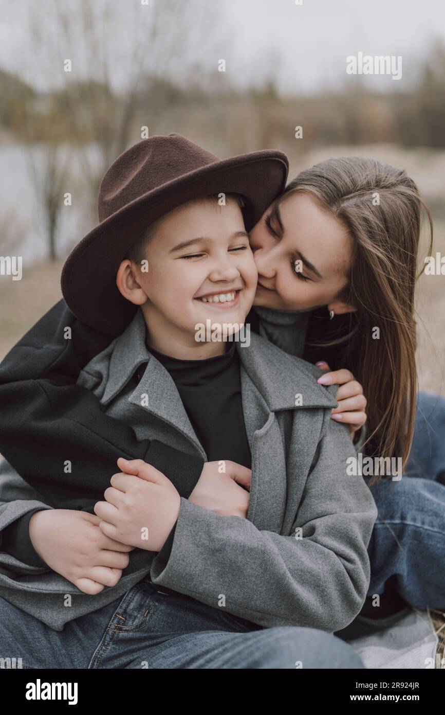Mother embracing son sitting on field Stock Photo - Alamy