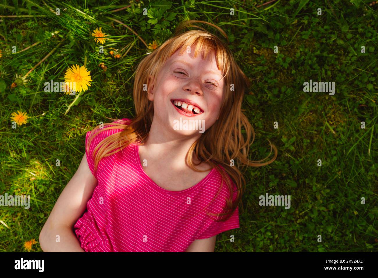 Happy strawberry blond girl lying on grass Stock Photo - Alamy