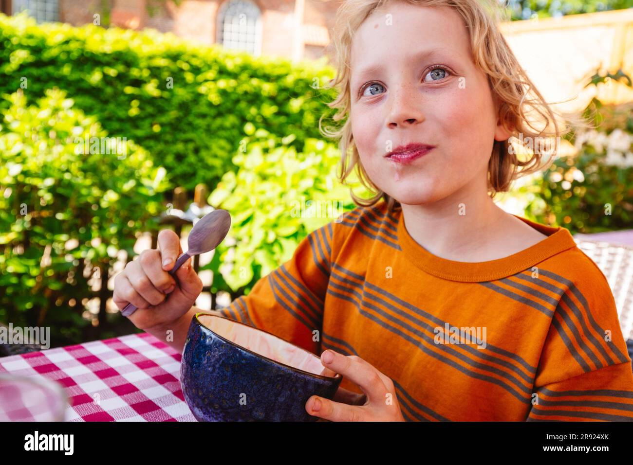 Blond boy eating desert in bowl Stock Photo - Alamy