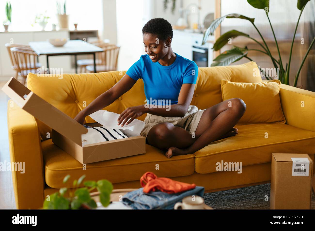 Happy woman unboxing packages at home Stock Photo - Alamy