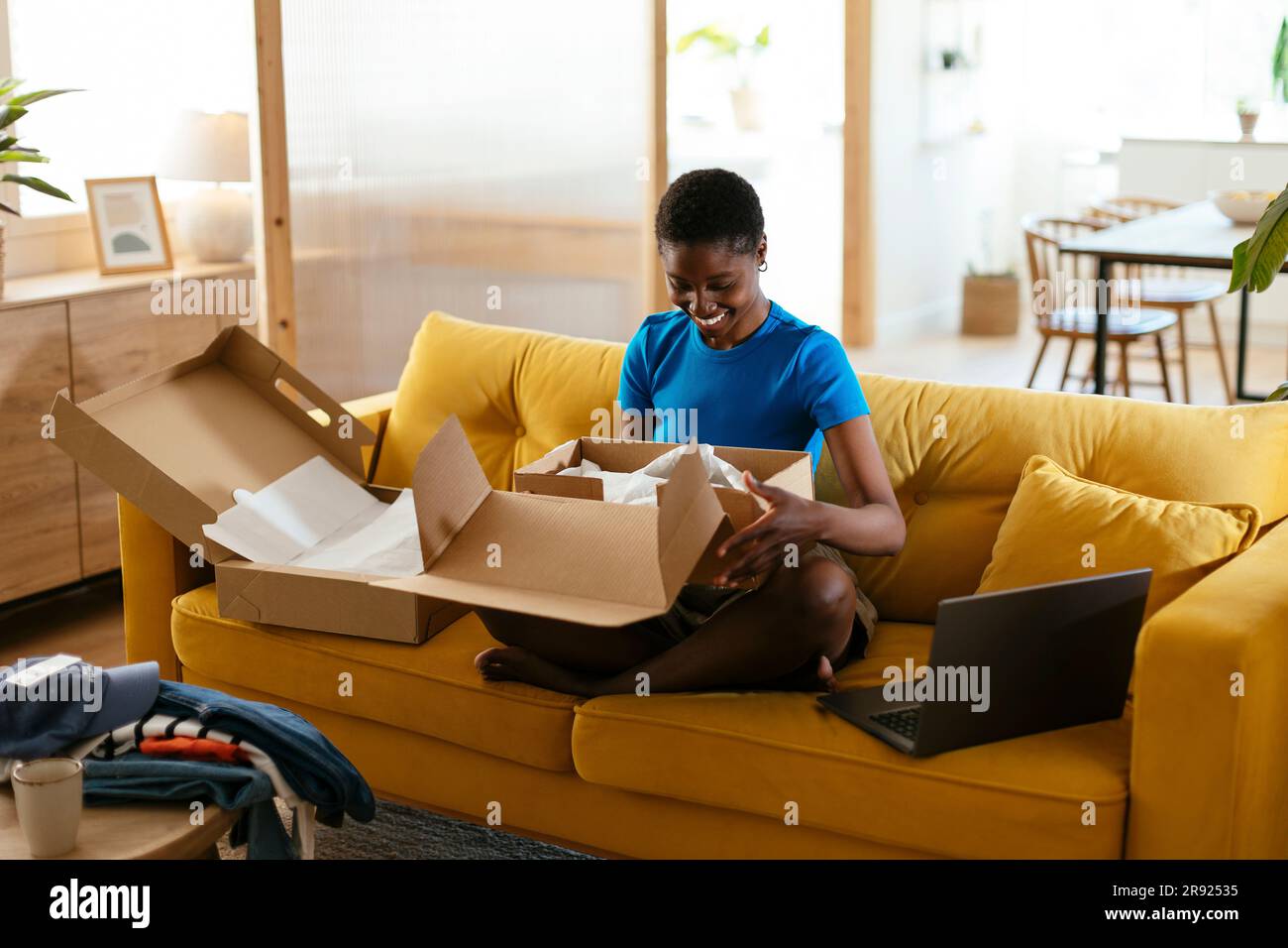 Happy young woman unboxing packages at home Stock Photo - Alamy