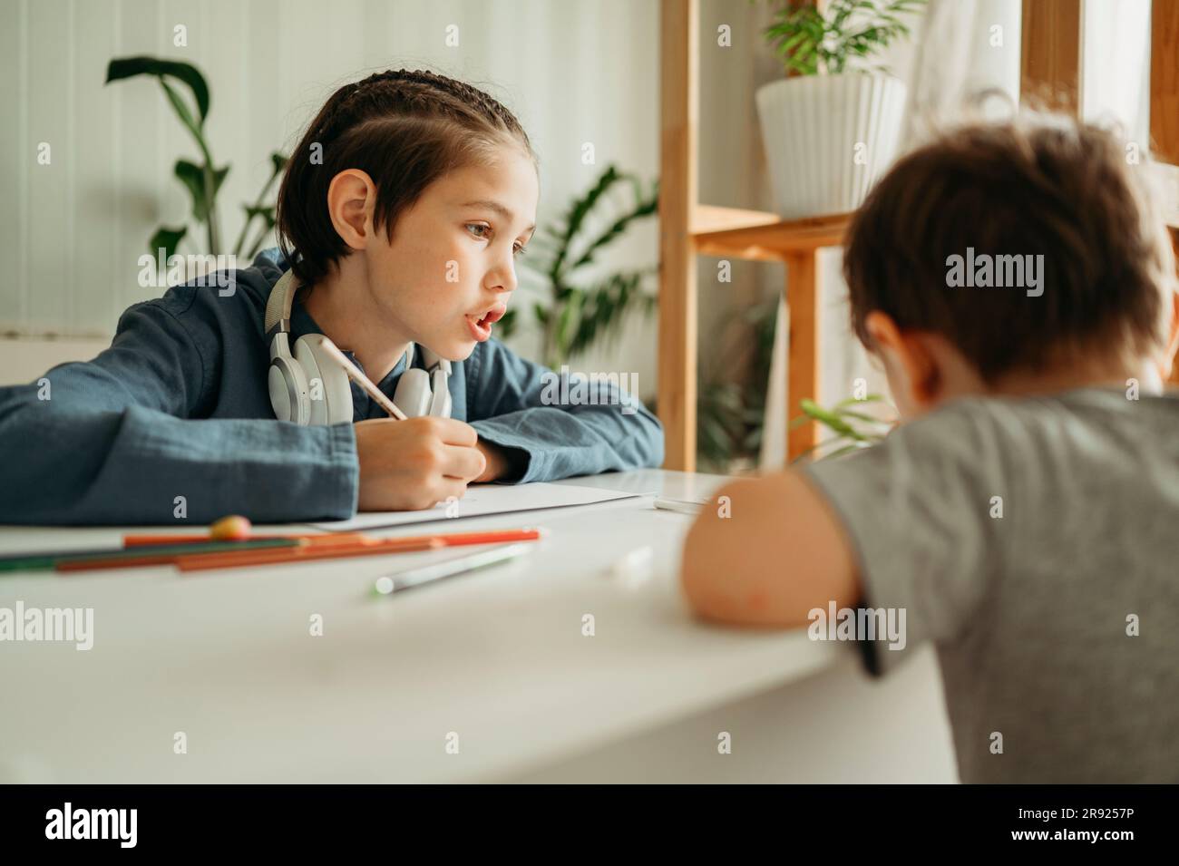 Boy talking to brother drawing at home Stock Photo - Alamy