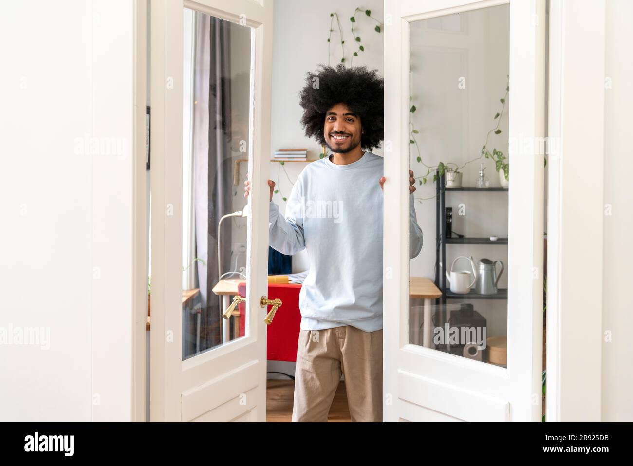 Smiling man opening doors at home Stock Photo - Alamy