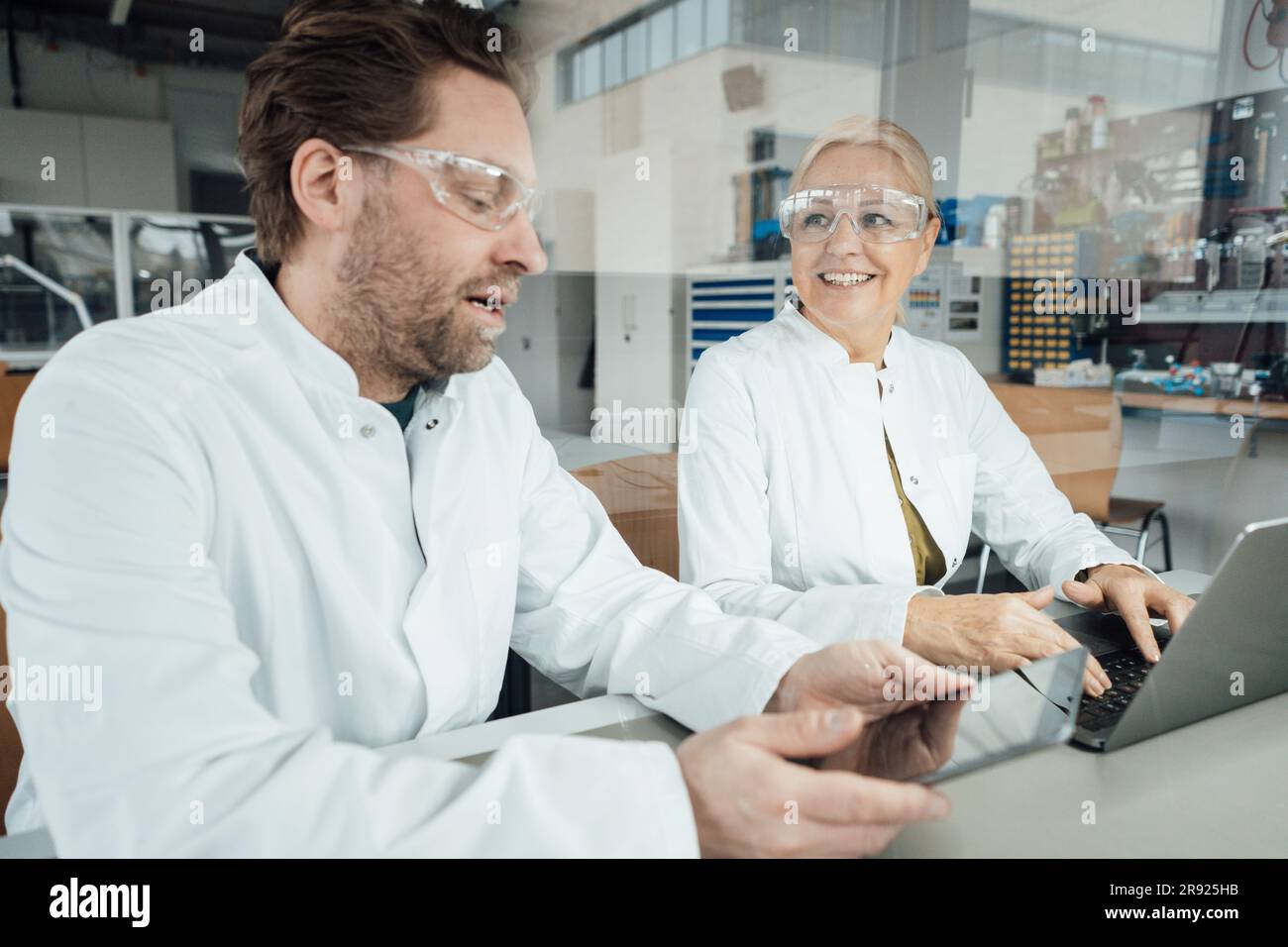 Mature scientist having discussion with colleague in laboratory Stock ...