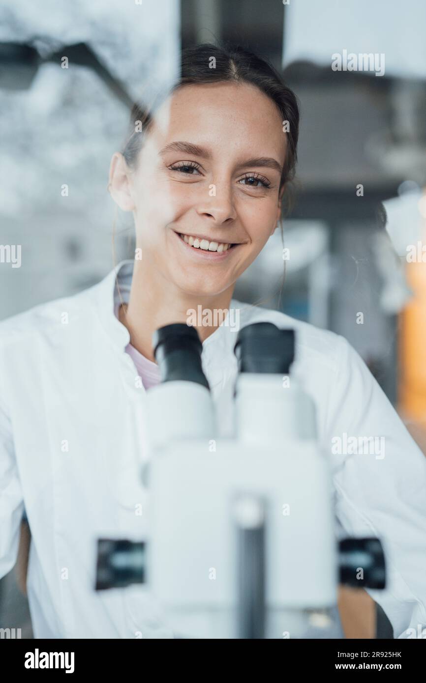 Young scientist looking through microscope hi-res stock photography and ...