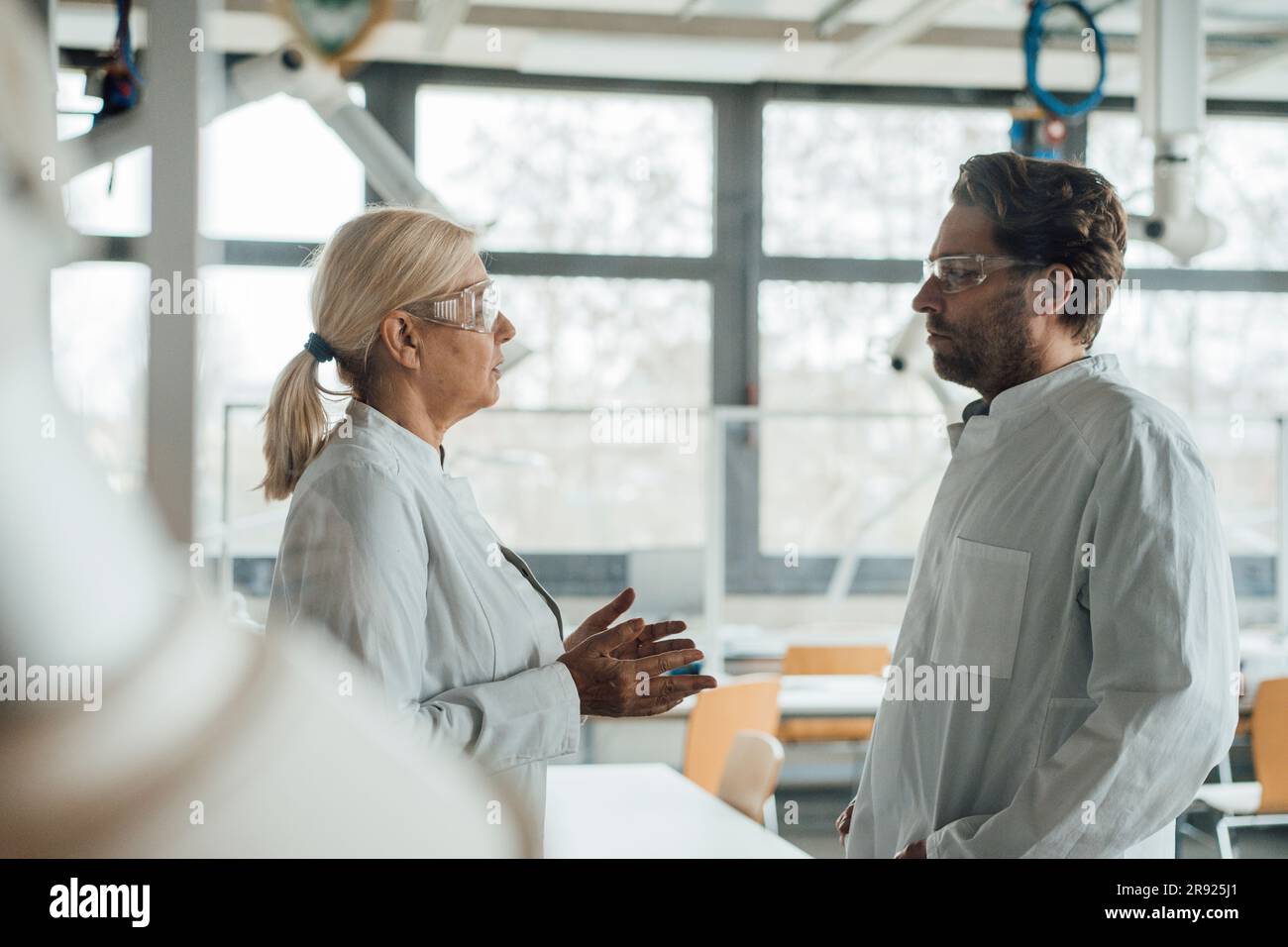 Senior scientist discussing with colleague in laboratory Stock Photo ...
