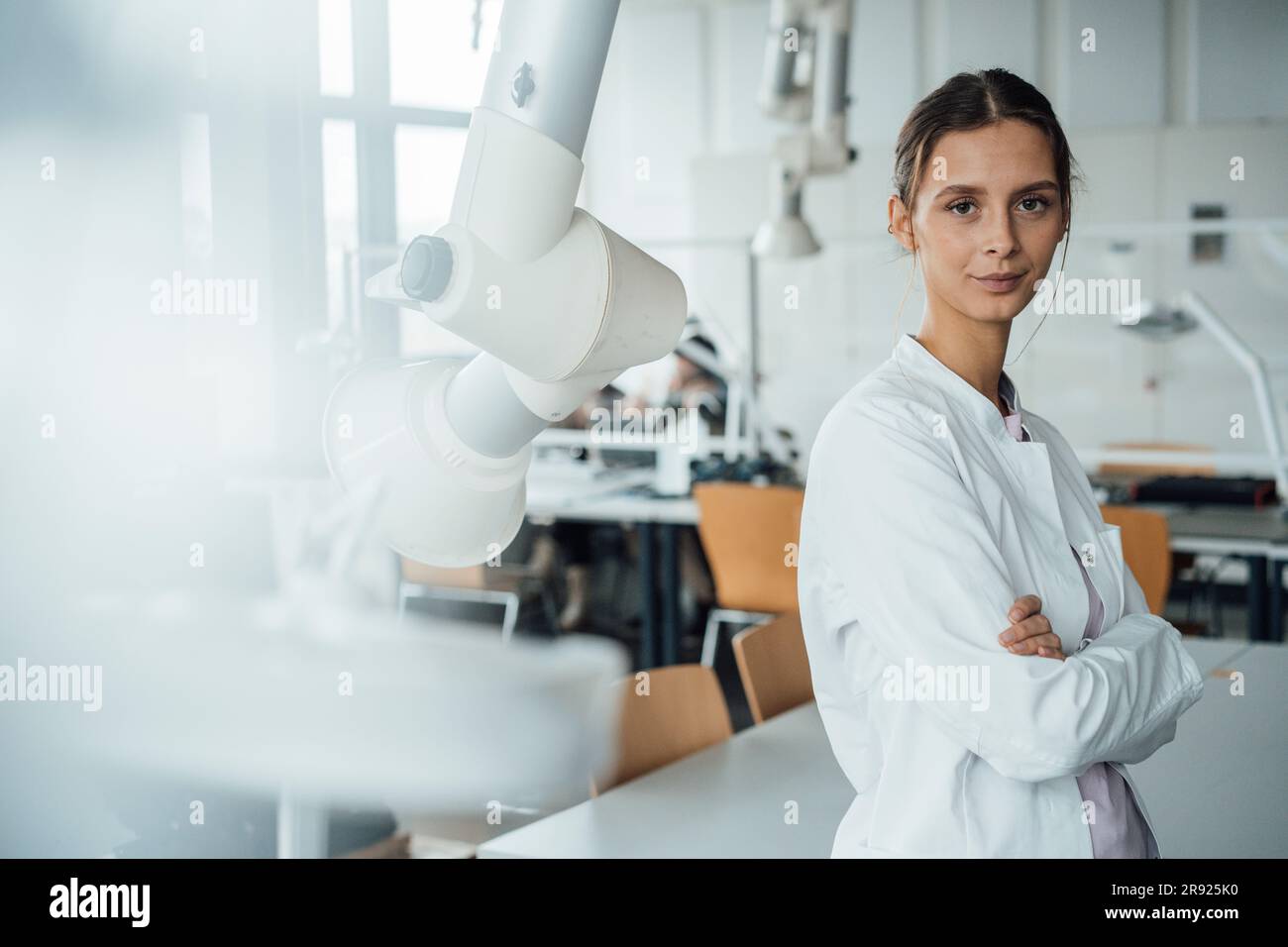 Smiling scientist standing by robotic arm Stock Photo - Alamy
