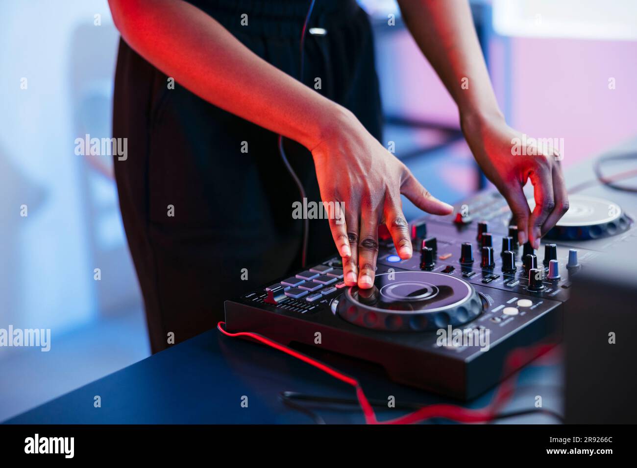 Female Dj operating sound mixer at home Stock Photo - Alamy