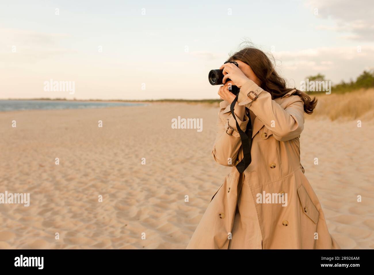 Woman photographing with camera at beach Stock Photo - Alamy