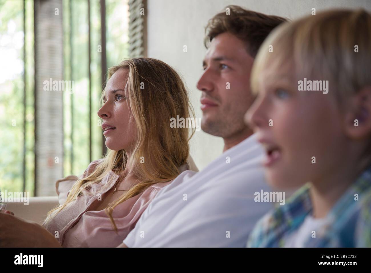Mother and father with son watching TV at home Stock Photo - Alamy