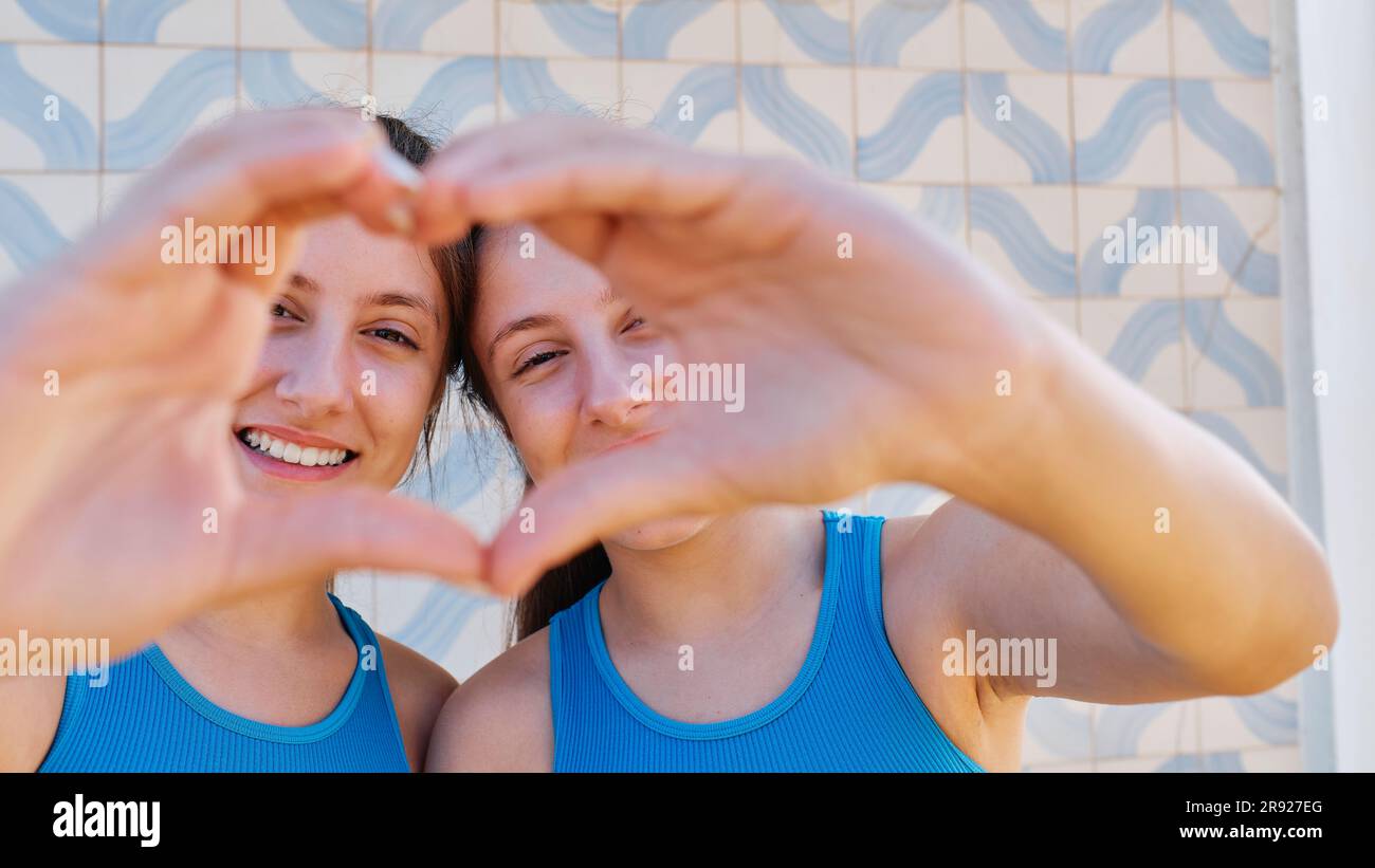 Happy girls gesturing heart shape Stock Photo - Alamy