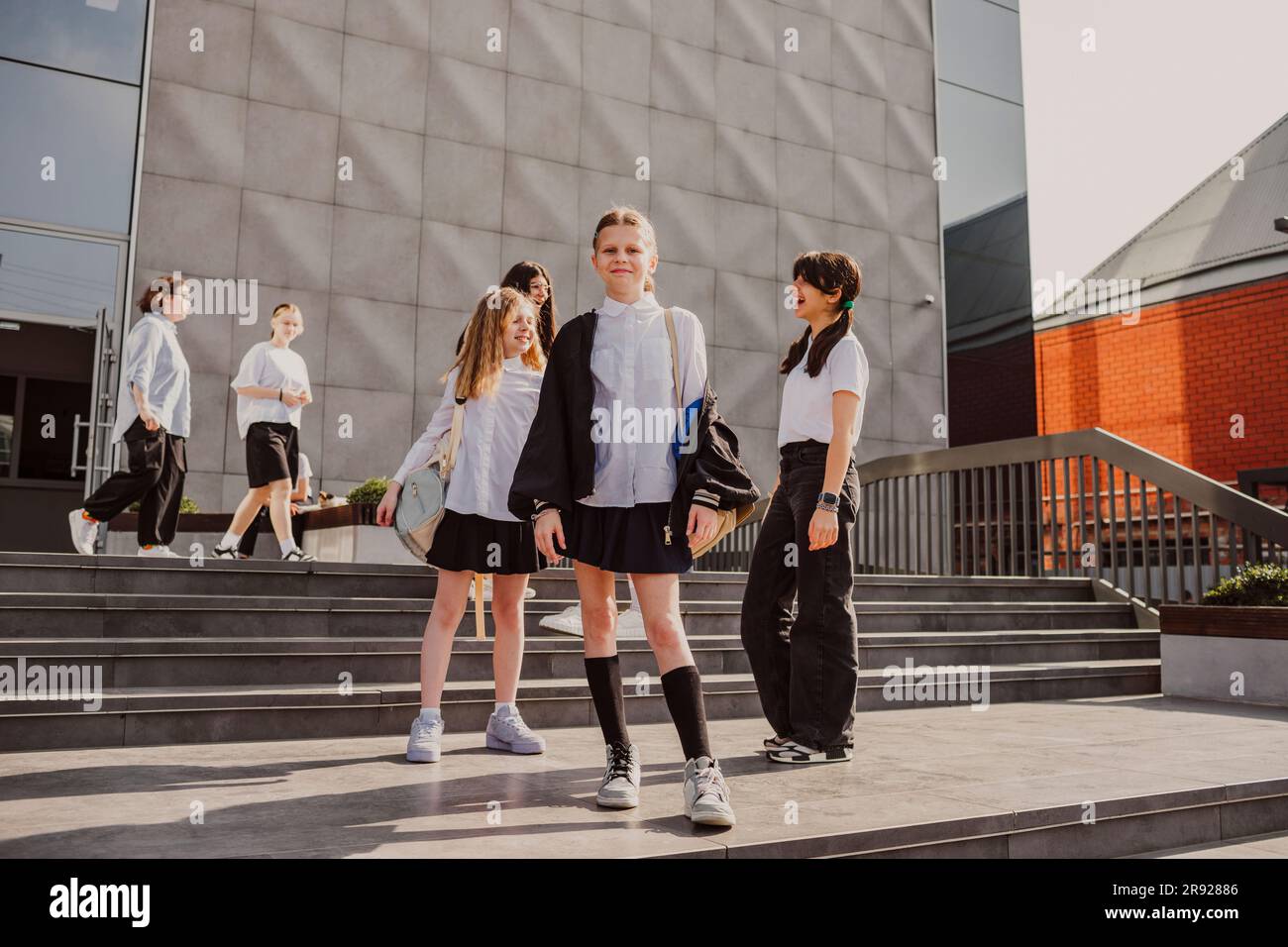 Schoolgirls standing by steps in front of school building Stock Photo ...