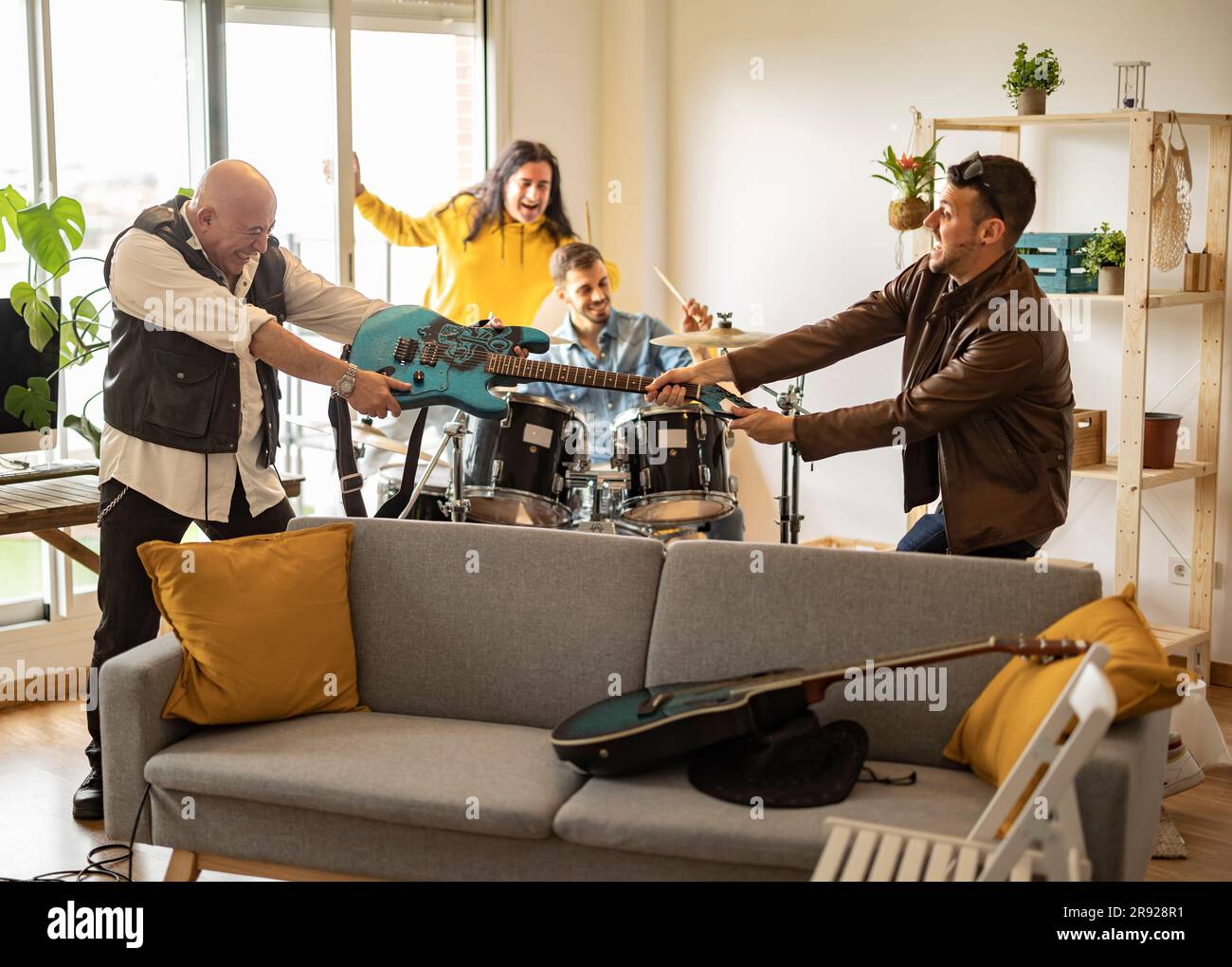 Happy musicians pulling guitar and having fun together at home Stock ...