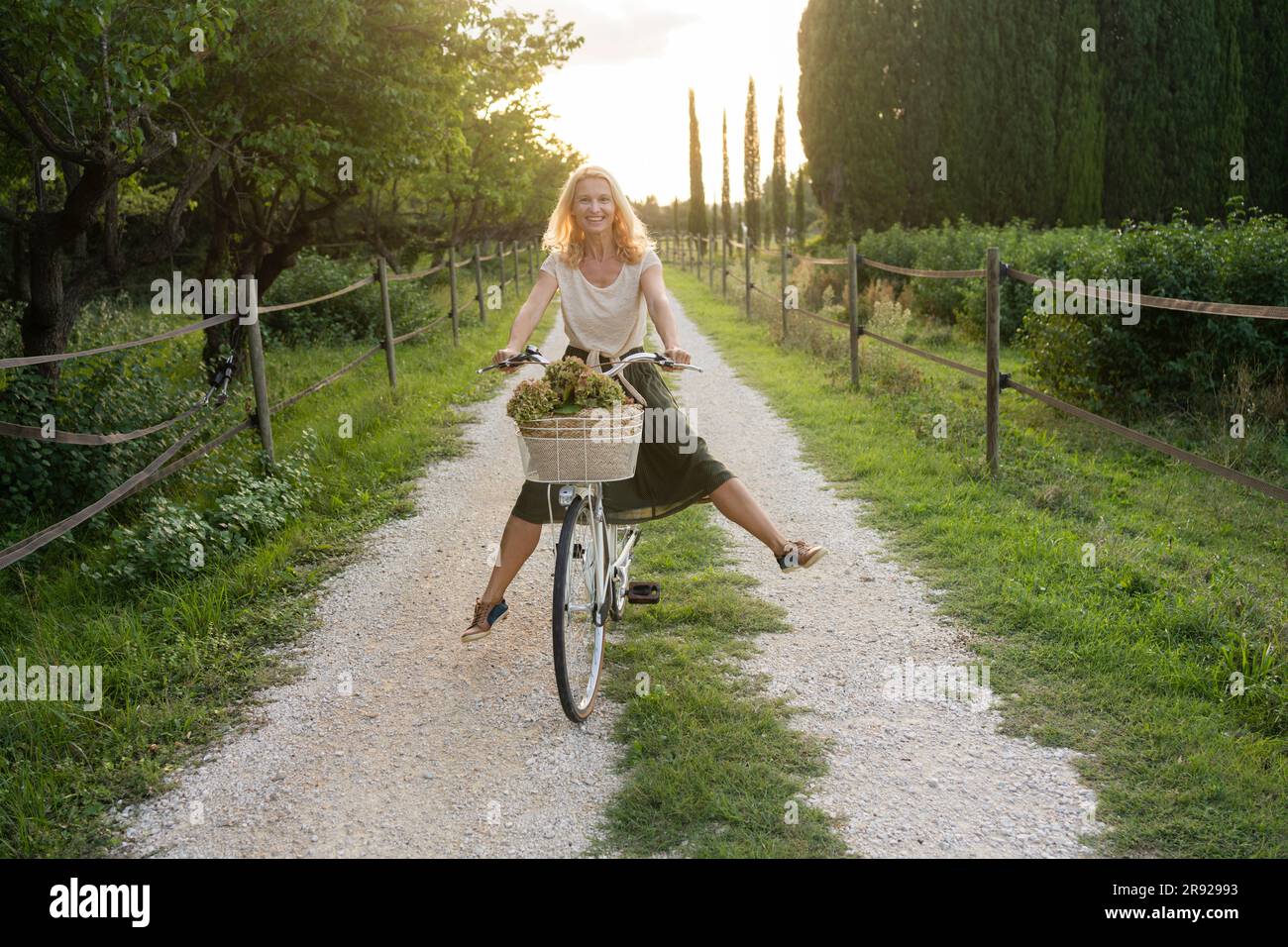Smiling mature woman riding bicycle hi-res stock photography and images ...