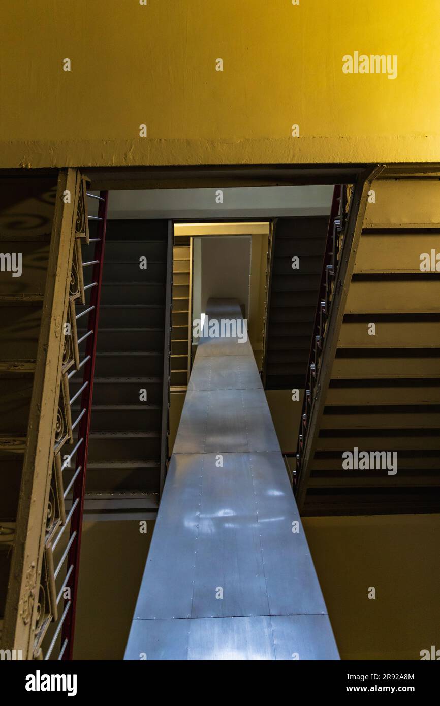 Look-up to staircase of old tenement building with colorful walls and ...