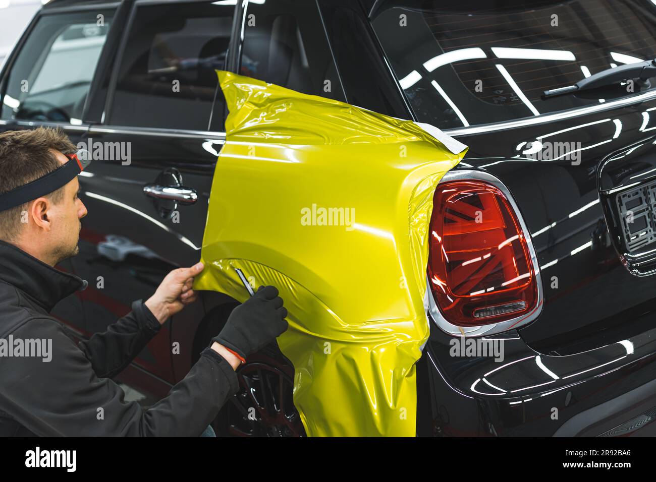 Back and truck of a car during car wrapping process at detailing ...