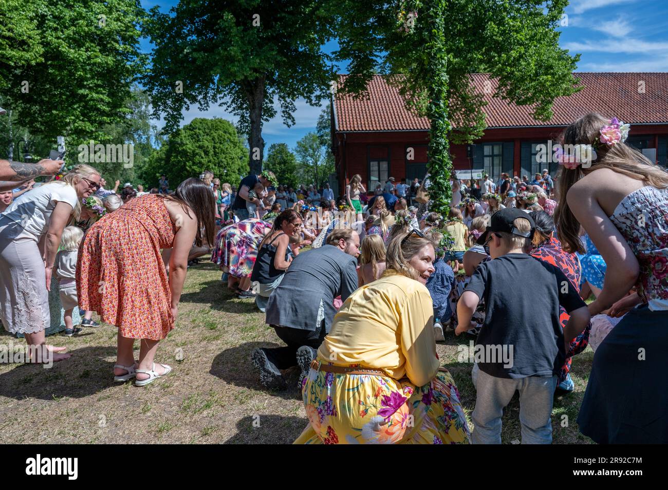 Traditional Swedish midsummer celebration with people dancing around ...
