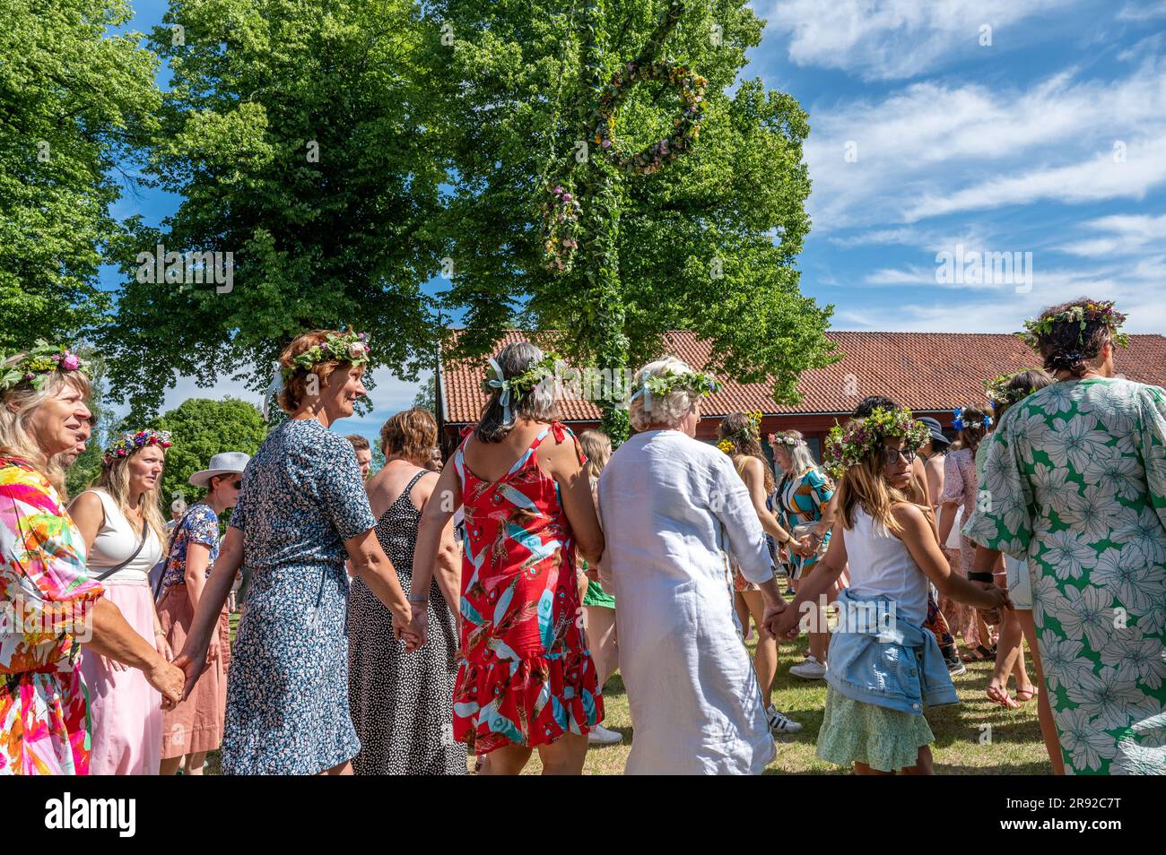 Traditional Swedish midsummer celebration with people dancing around ...