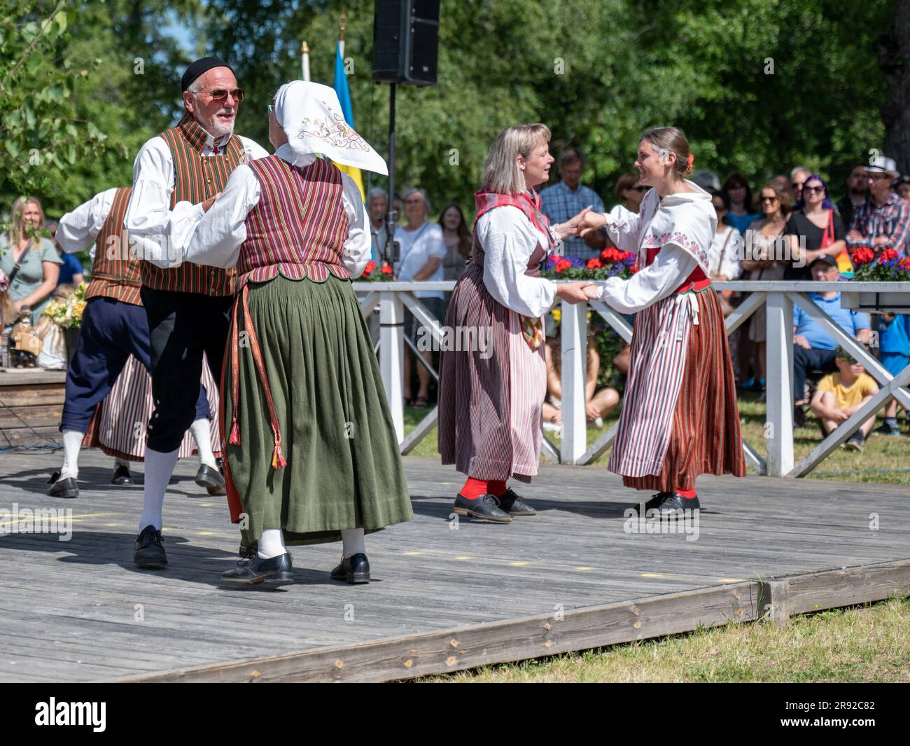 Traditional Swedish midsummer celebration with Folkdance and dancing around the May pole in ...