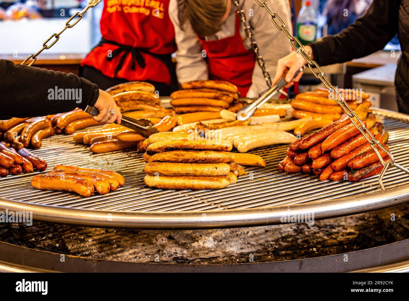 the chefs busily prepare a meal of hot dogs on a hot grill in a ...