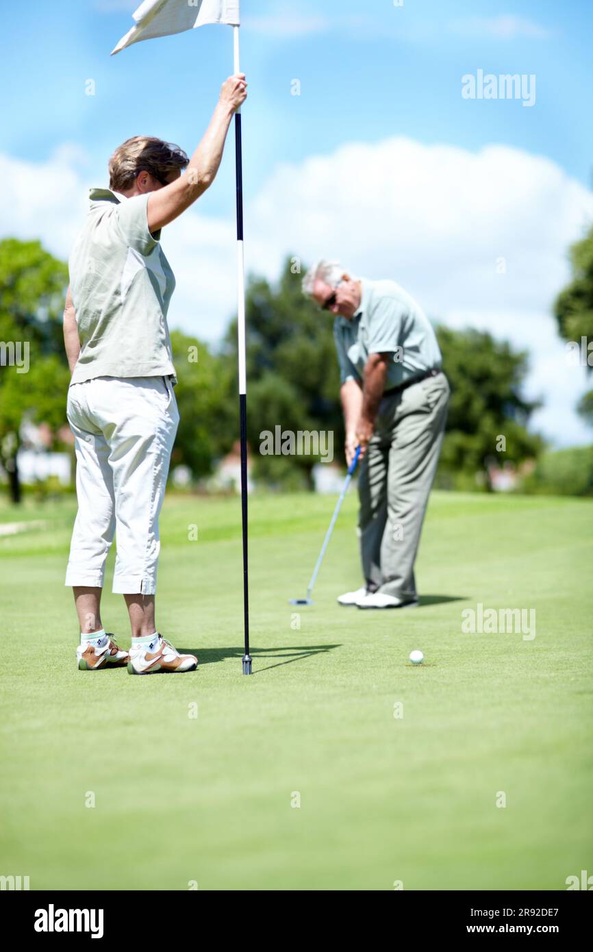 Woman with flag, old man or golfer on golf course for a birdie, putting ...