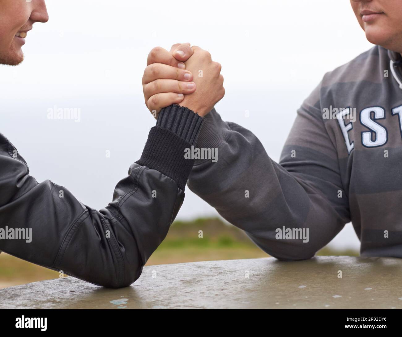 Hands, friends and competition with men and arm wrestling in nature for ...