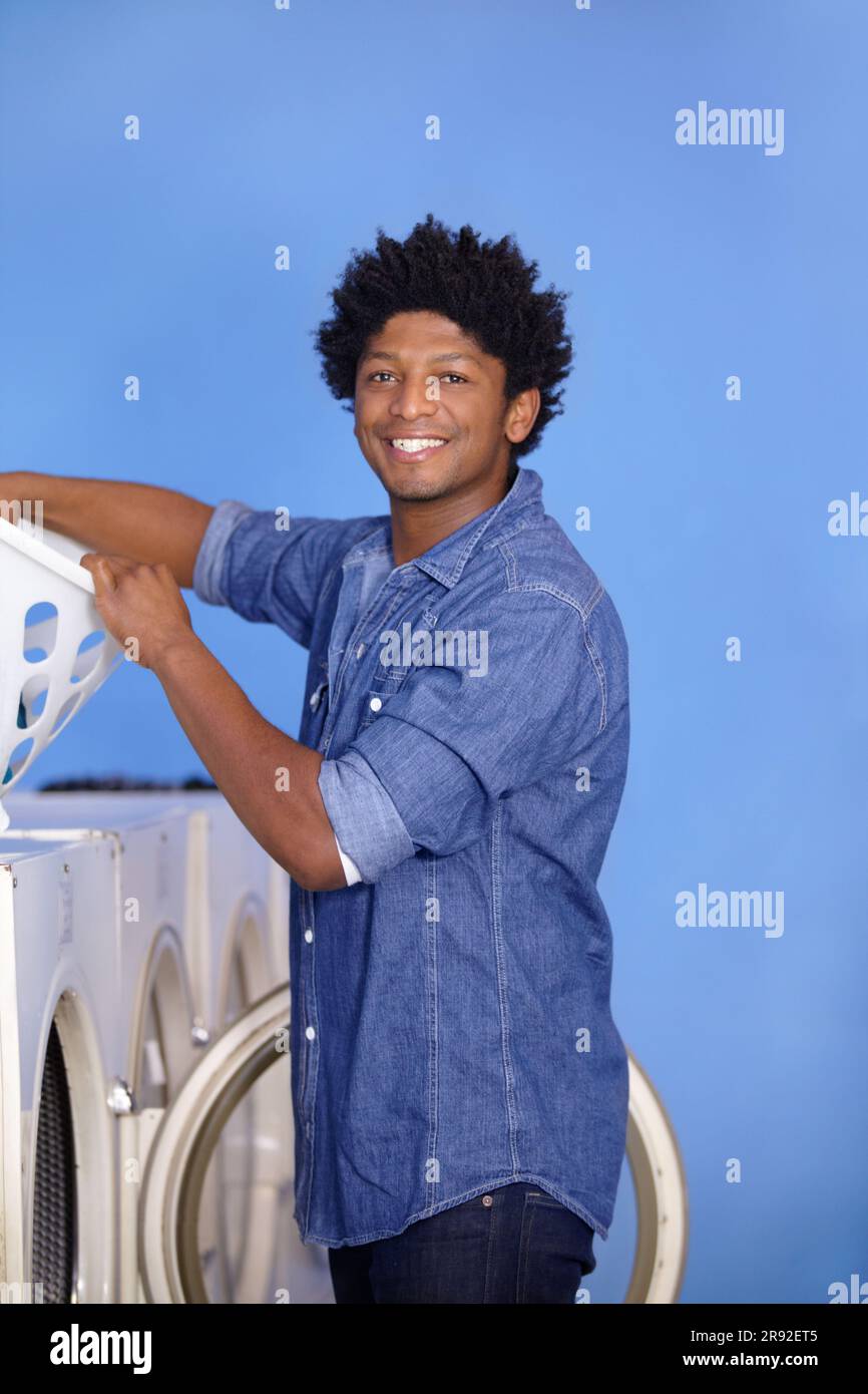 Laundry, portrait of a black man at washing machine and basket at ...