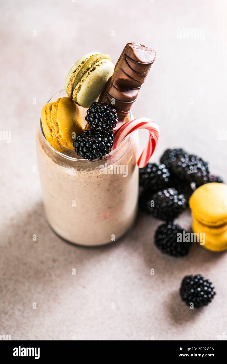 Chocolate indulgent extreme milkshake with macaroons, berry and sweets ...