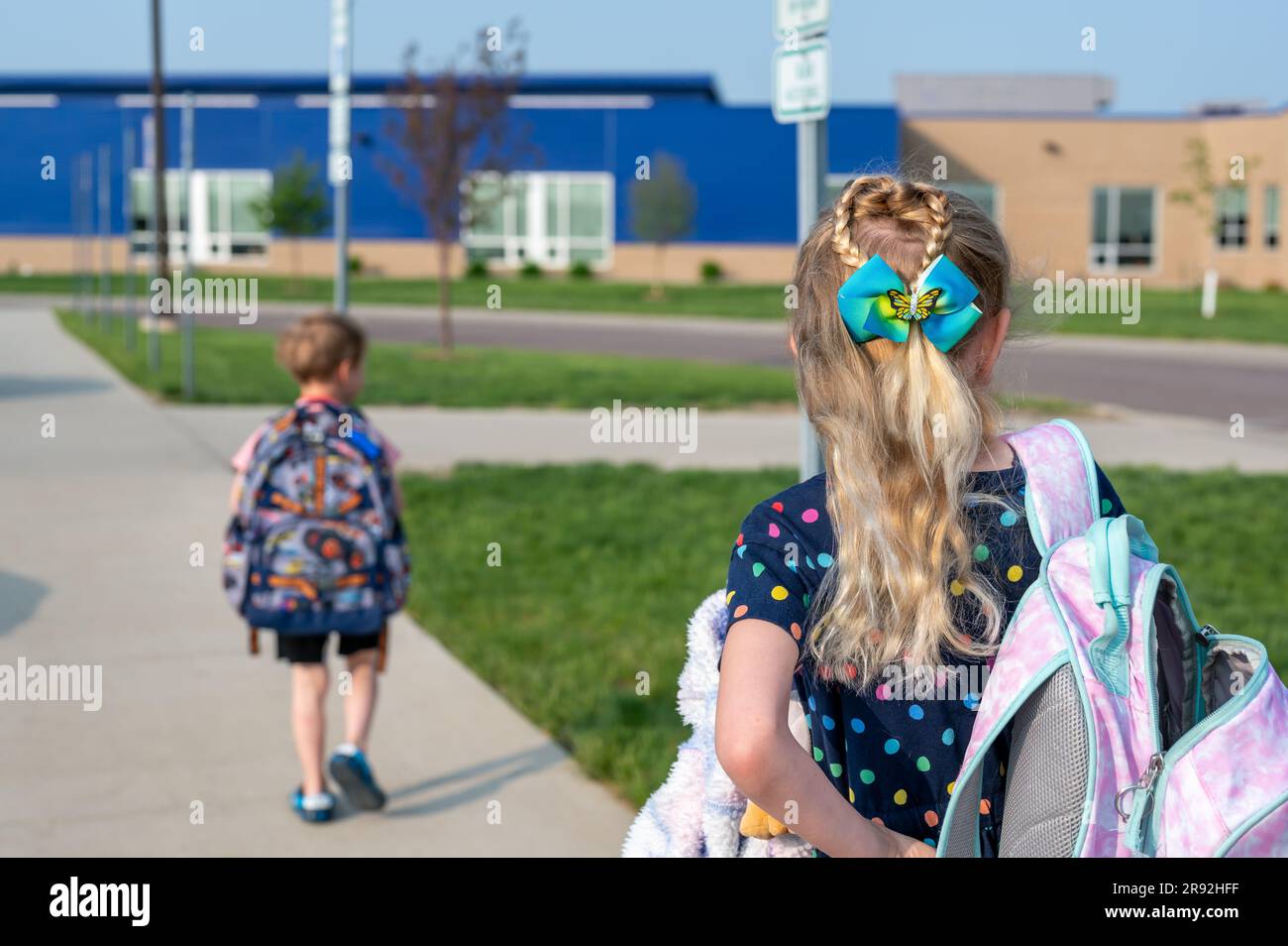 Behind two children with backpacks walking to school Stock Photo - Alamy