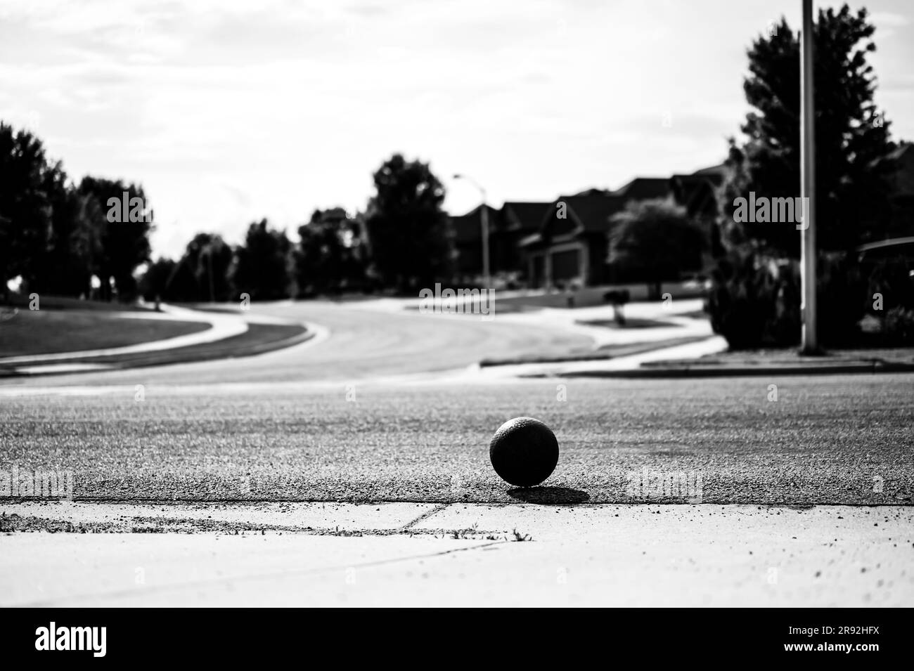 Chasing a ball that has crossed the street by rolling into a road Stock ...