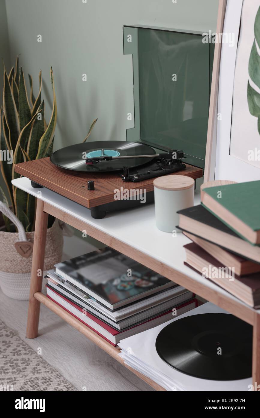 Stylish turntable with vinyl record on console table in room Stock ...